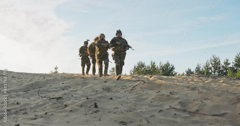 Military men in uniform on mission, coming down from observation post ...