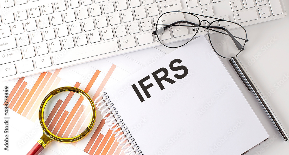 IFRS text written on a notebook with keyboard, chart,and glasses Stock ...