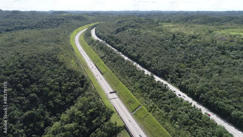 Panning wide of landmark highway road at green forest trees and ...