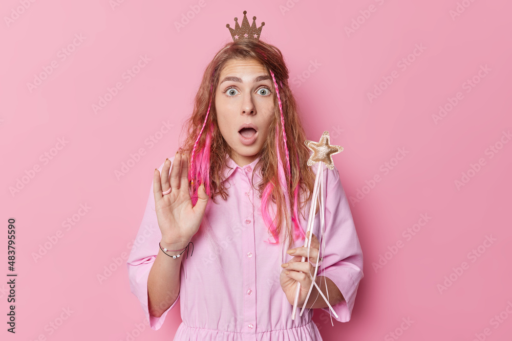 Shocked scared young woman with long hair stares impressed at camera ...