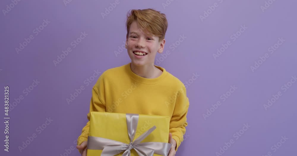 Amusing happy pleased little boy embracing gift box, in pleasure ...
