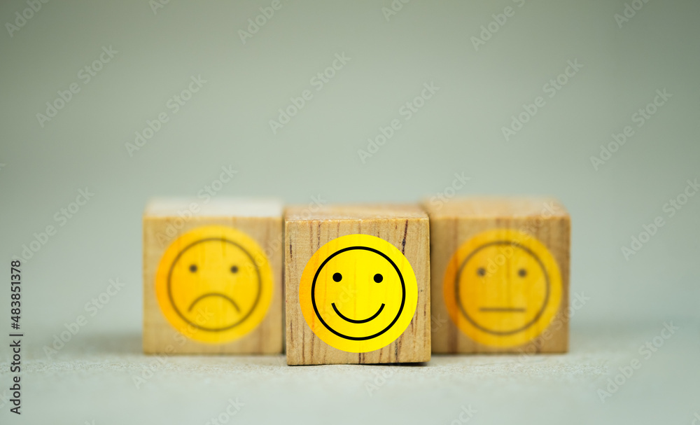 Choose square wooden block with a face grin emoticons. A survey, poll ...