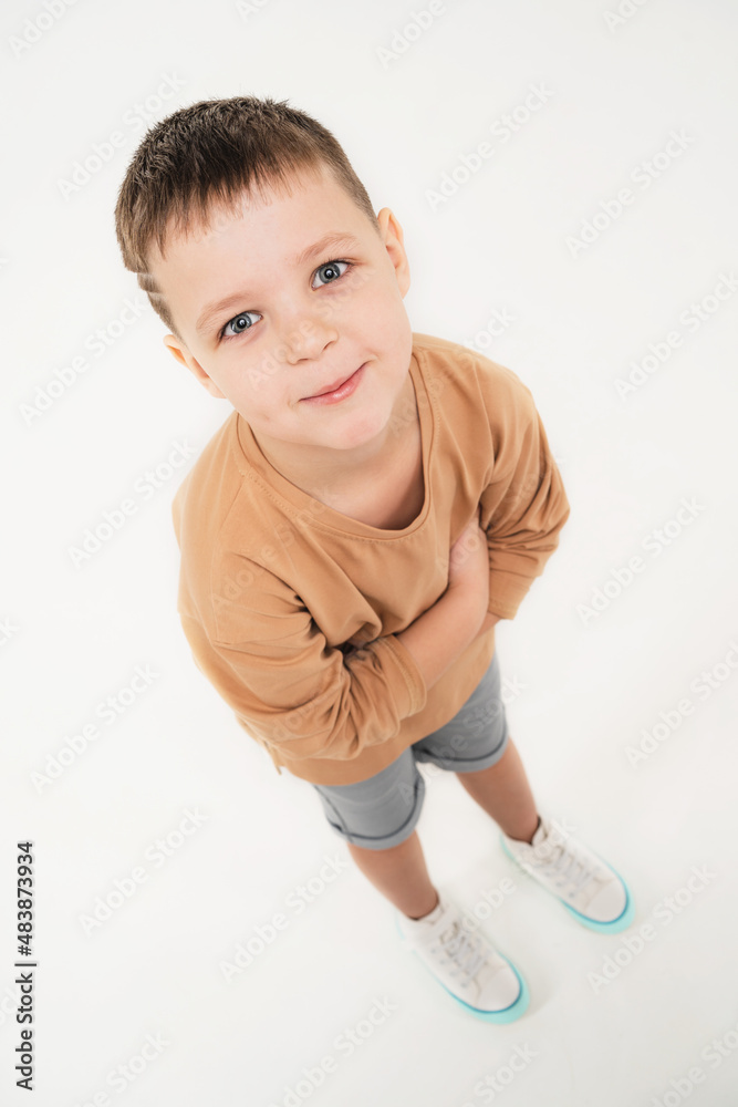The child looks at the camera from below. The kid bulges his eyes and ...