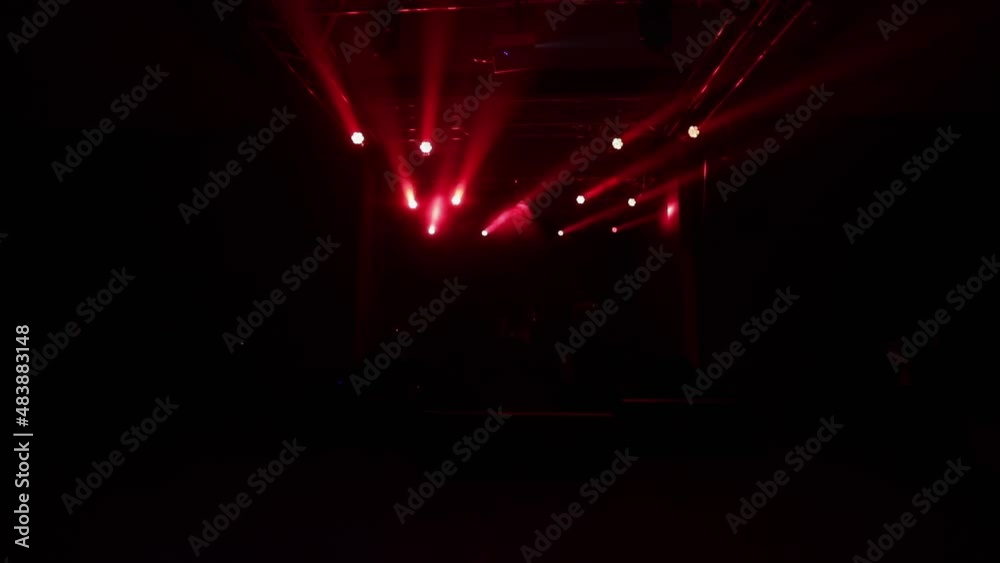 A red concert stage light that moves and illuminates the space through ...