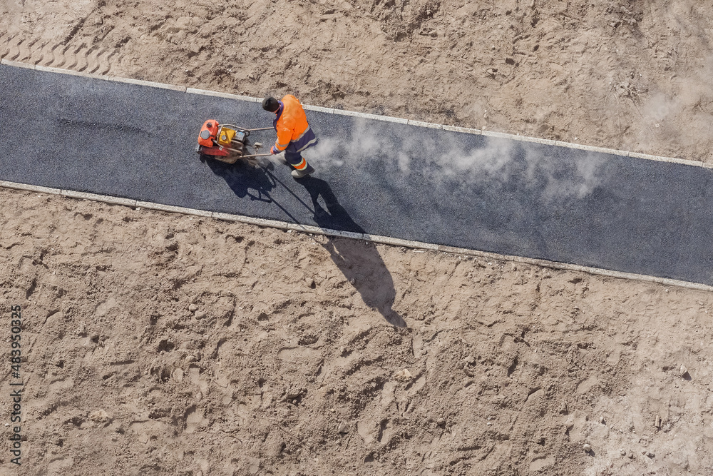 Hot asphalt paving road construction site work man vibratory plate ...