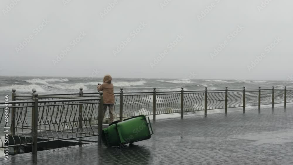 Unrecognizable woman taking pictures of the sea on her phone during a ...