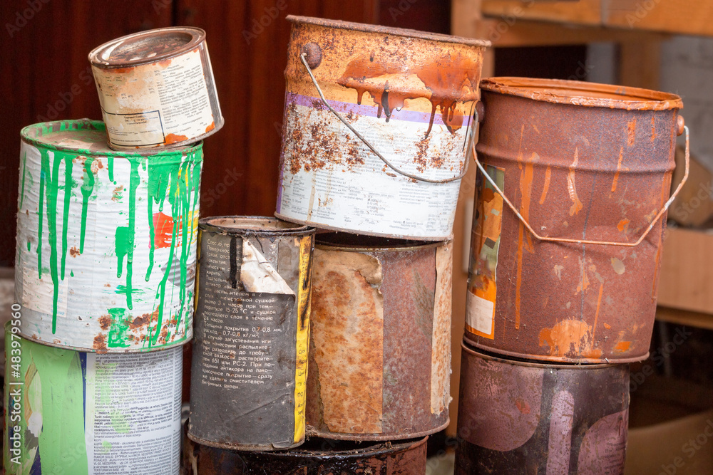 A collection of paint cans, buckets, toxic and hazardous material ...