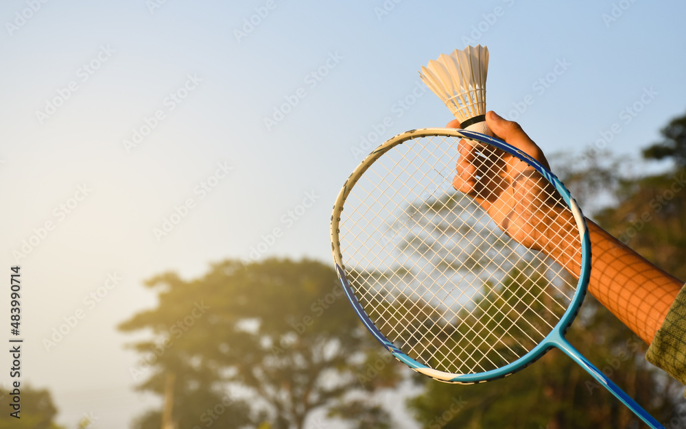 Badminton racket and new badminton shuttlecock holding in hand of ...