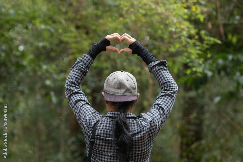 young man shows his hands above his head and makes a heart-shaped ...
