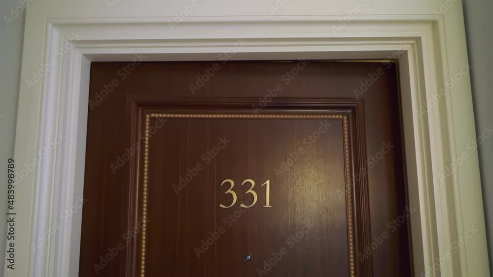 Entrance door in apartment hallway. Hotel room number enter in a ...