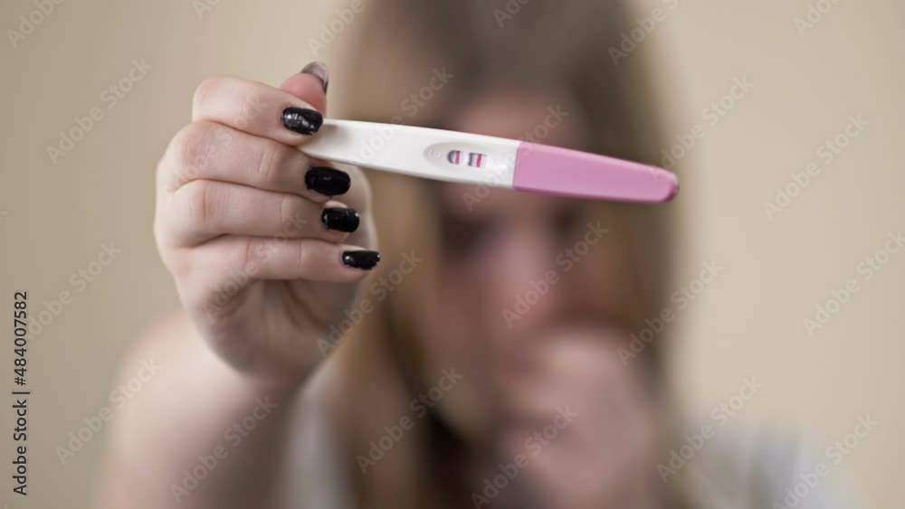 Teenage girl shows a strip test for pregnancy. Two lines, positive ...