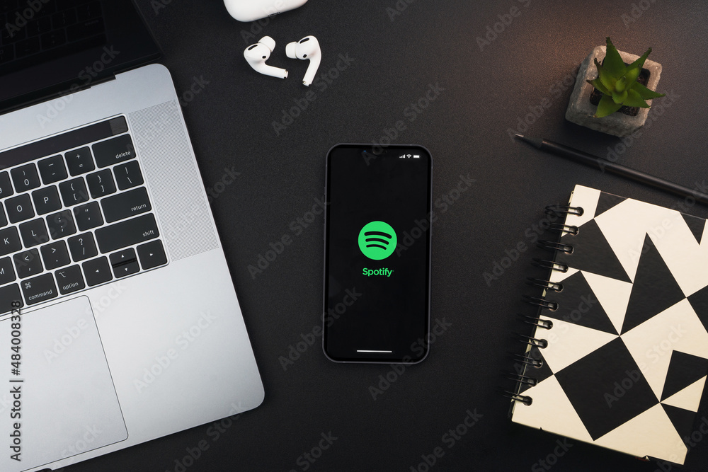 Spotify music app on the smartphone screen on black background table ...