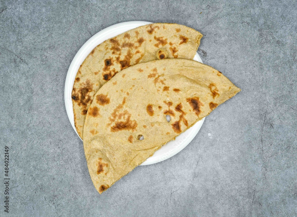 Sada tandoori roti in white plate pakistani food top view on grey ...