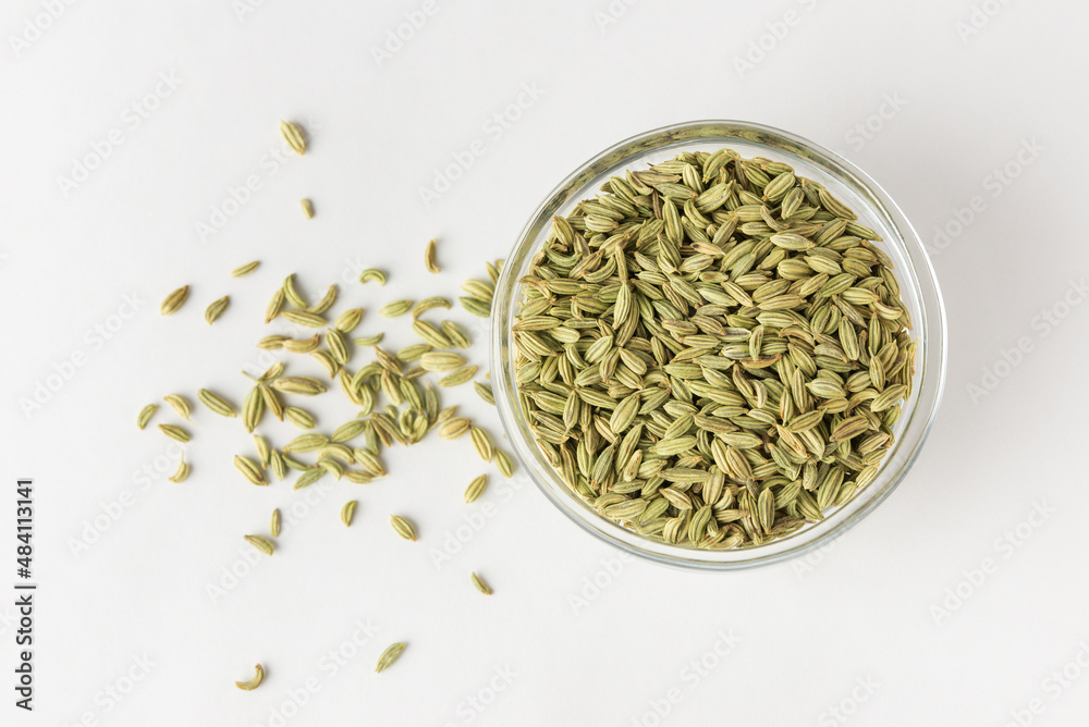 Scattered green dry fennel seeds on white background. fennel is ...