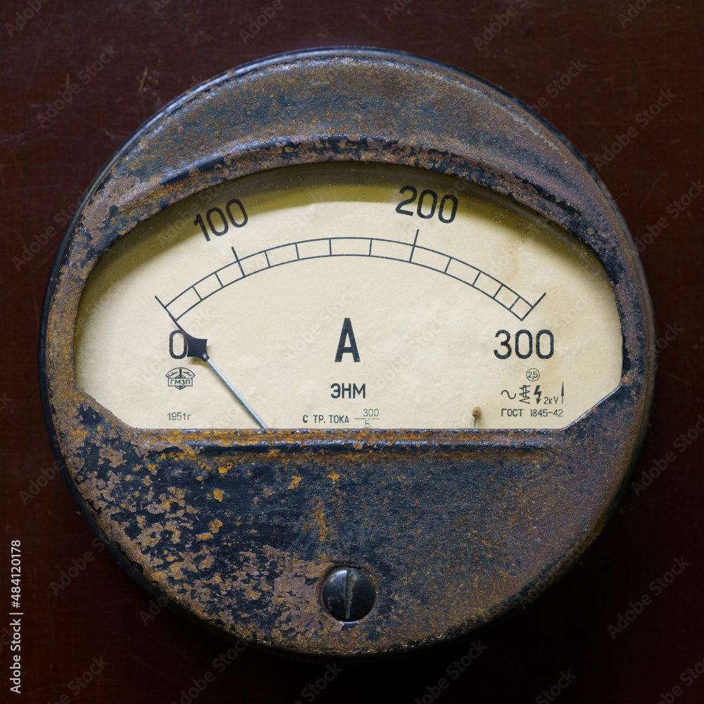 An ancient ammeter mounted on a textolite plate. Old electric current ...