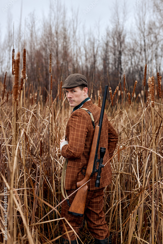 outdoor hunting on wild animals at autumn season. Man holding shotgun ...