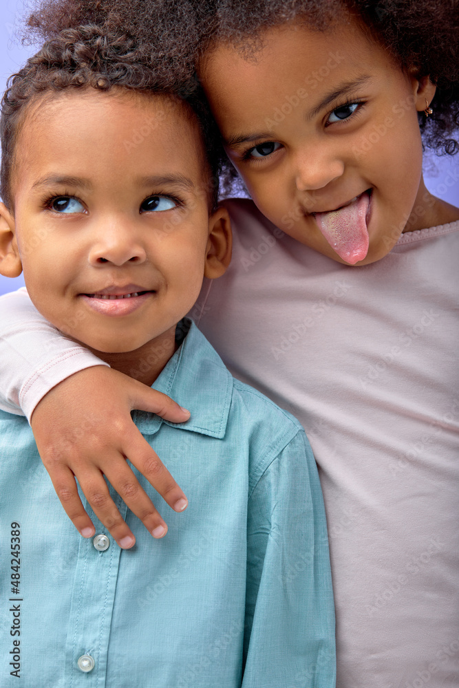 Two cheerful black sister and brother having fun while standing ...