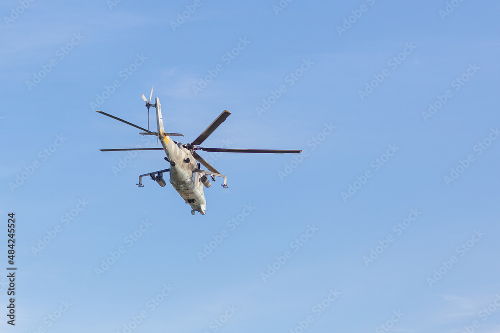 A Russian military helicopter is high in the peaceful blue sky ...