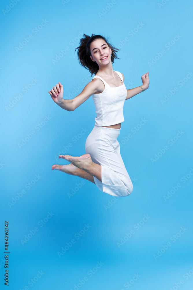 Happy girl jumping for joy, mid-air pose, sporty, active and energetic ...
