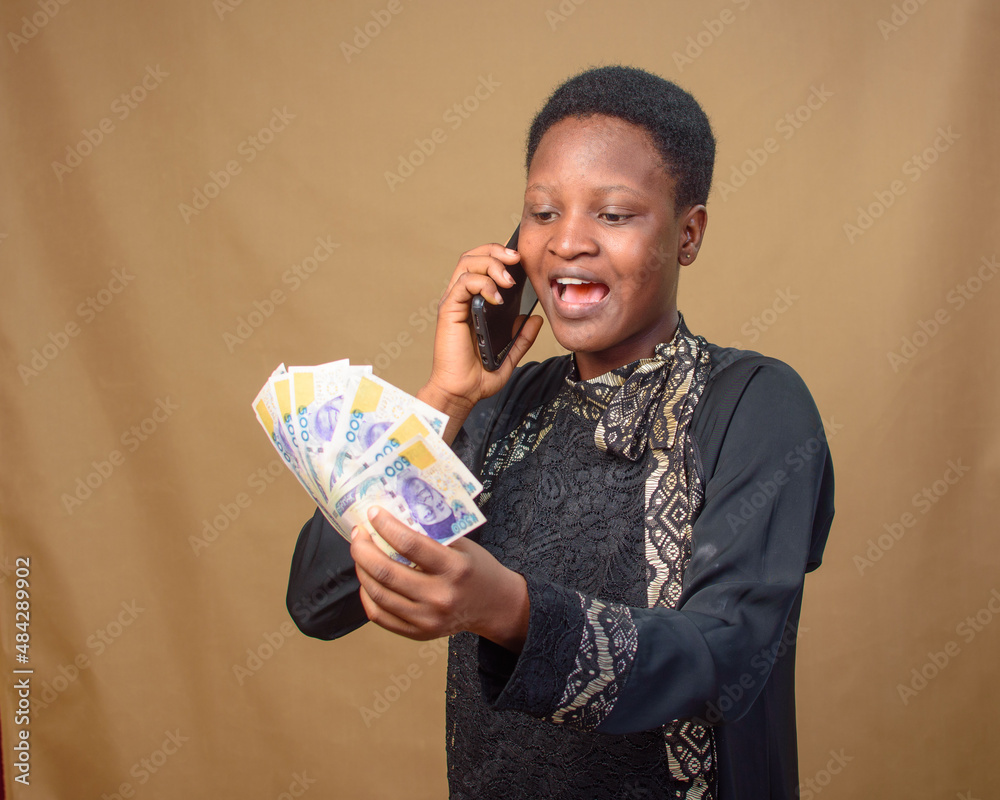 African Nigerian lady excited as she stares at the spread of multiple ...