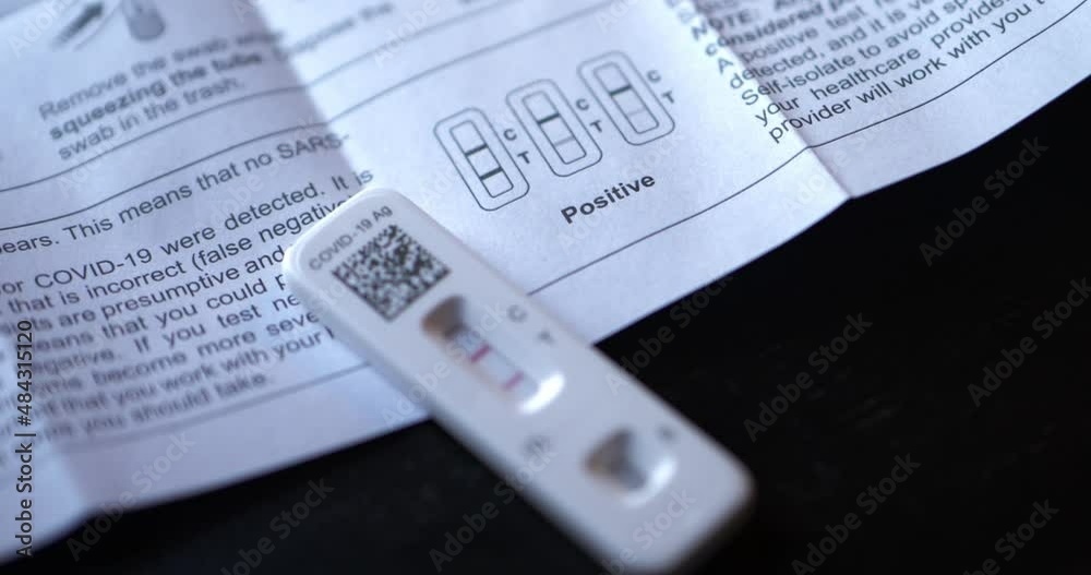 Covid 19 positive at home antigen test kit on black table with ...