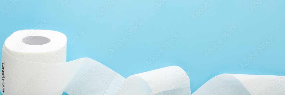 Soft, white unrolled toilet paper on light blue table background ...