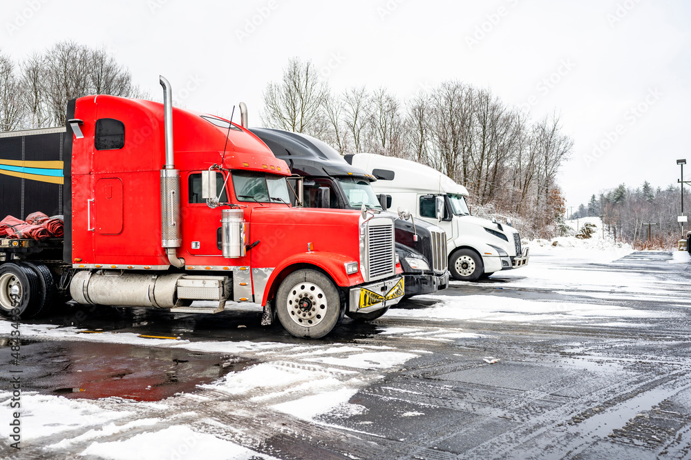 Row of big rigs industrial semi trucks with semi trailers standing on ...
