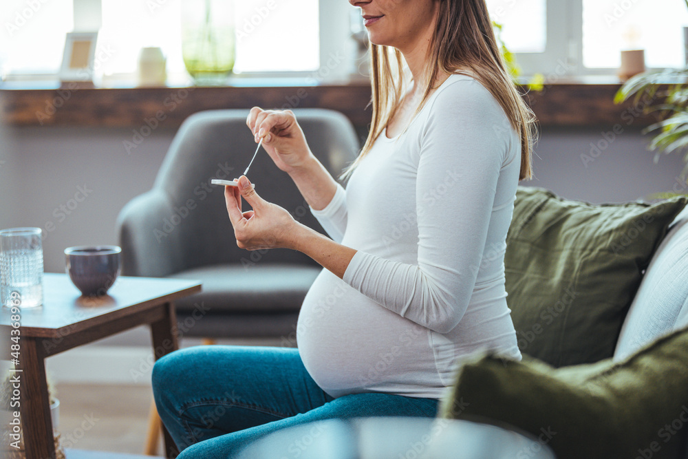 Pregnant woman taking a Self-swabbing home tests for COVID-19 at home ...