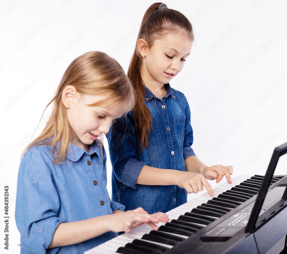 Music lesson. Two child girls in music school learning to play the ...