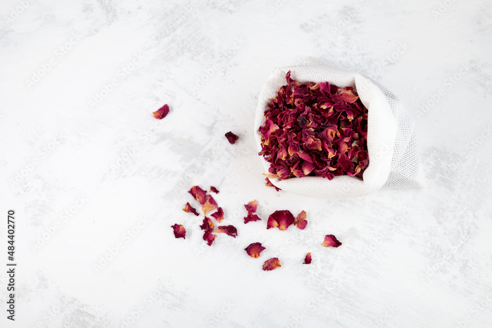 Dried Pink rose petals in pouch on light grey background, top view ...