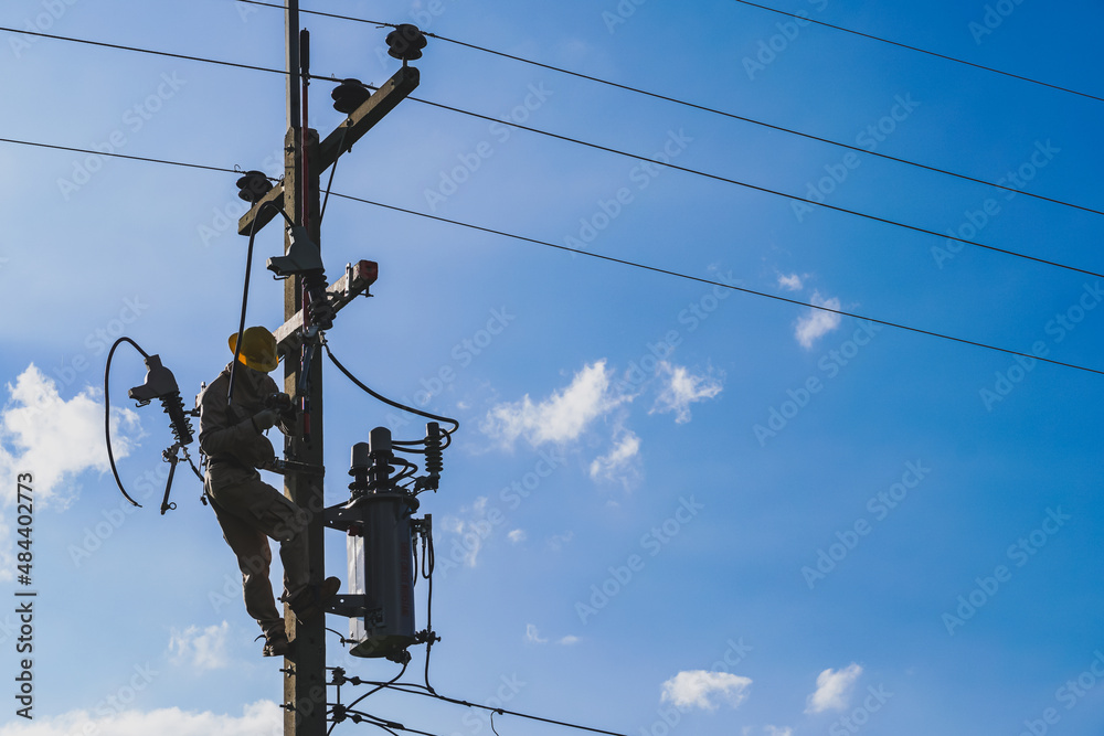 The silhouette of power lineman replacing a transformer and hotline ...