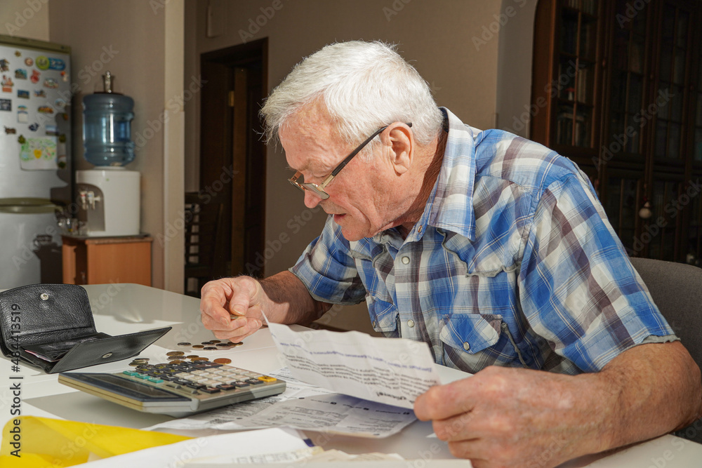Senior man sitting at the table and calculating finances. Old man ...