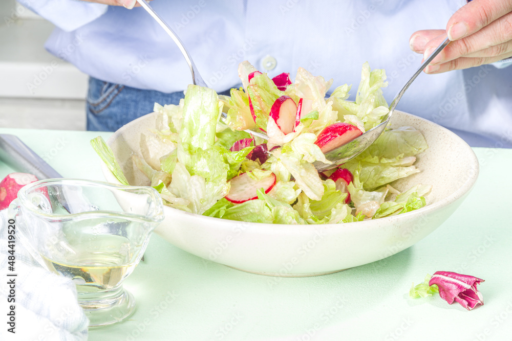 Making spring vegetable salad with from lettuce leaves, radishes ...