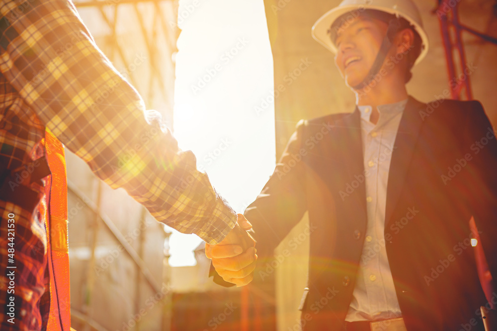 Architect and engineer construction workers shaking hands while working ...