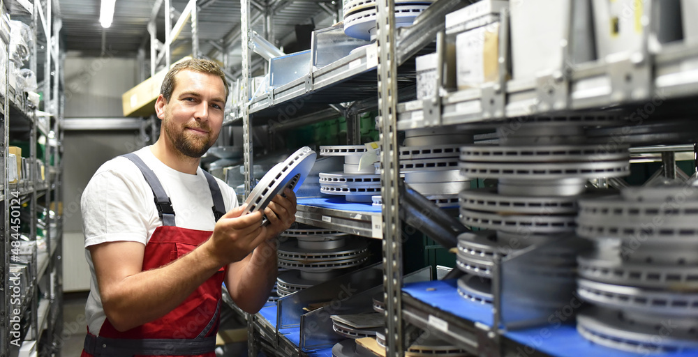 portrait friendly worker in a warehouse and trade for car spare parts ...
