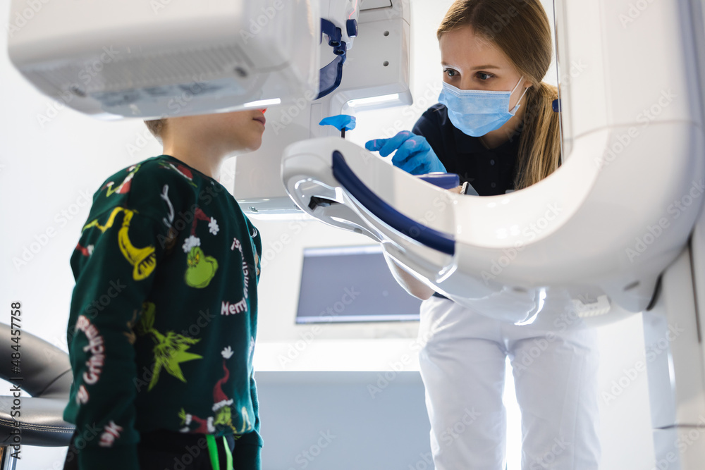 Radiographer taking panoramic teeth radiography to a little boy using ...