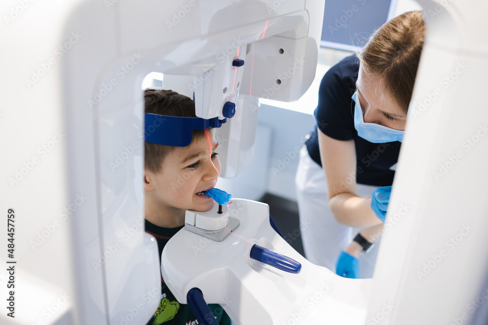 Radiographer taking panoramic teeth radiography to a little boy using ...