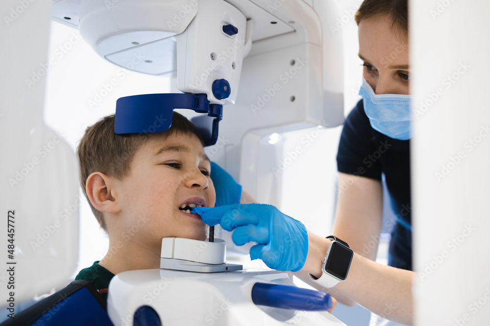 Radiographer taking panoramic teeth radiography to a little boy using ...