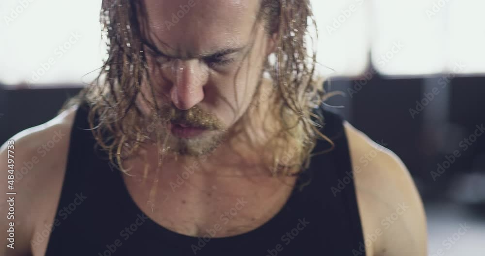One muscular young man serious focused sweating breathing heavily ...