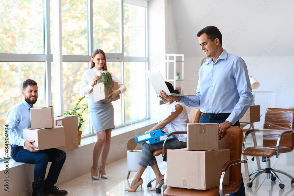 Young man with laptop in office on moving day Stock Photo | Adobe Stock