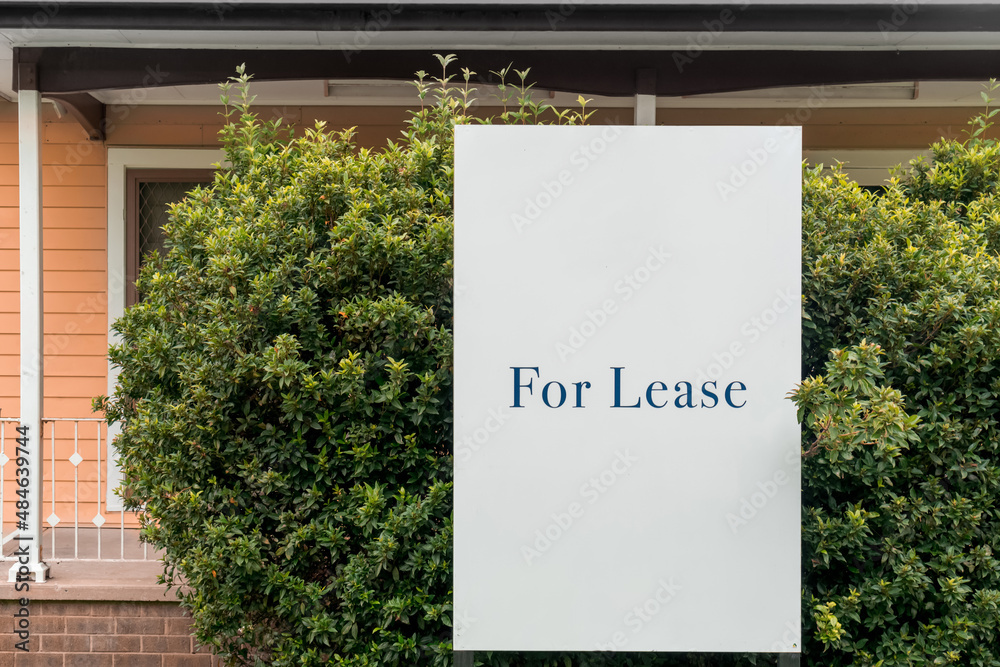 For lease sign on a white display outside of a house in Australia. Investment property real ...