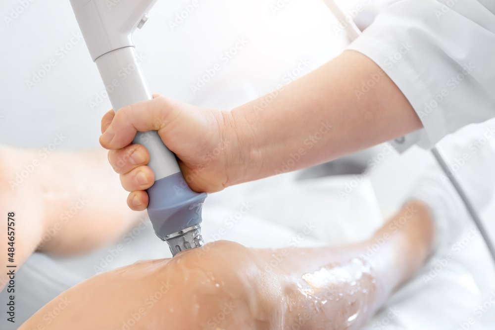 Closeup detail doctor medician hand do extracorporeal shock wave ...