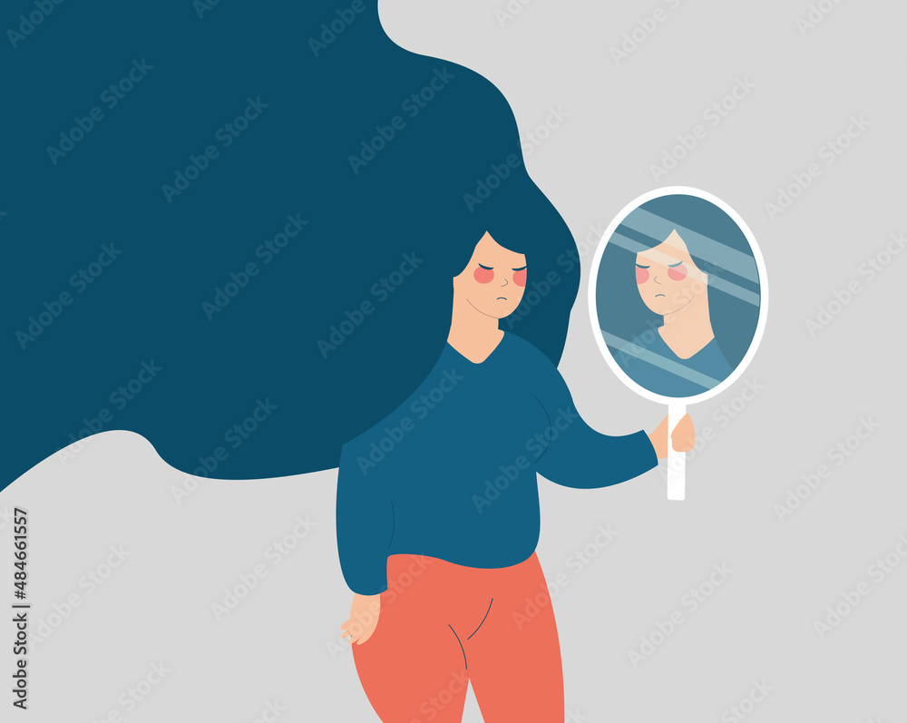 Young woman looks on her reflection in the mirror in a sad way. Girl ...