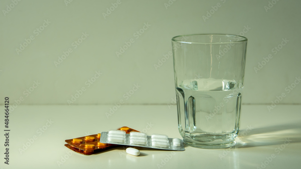 Pasillas des inflamatorias analgésico y antifebril con un vaso de agua ...