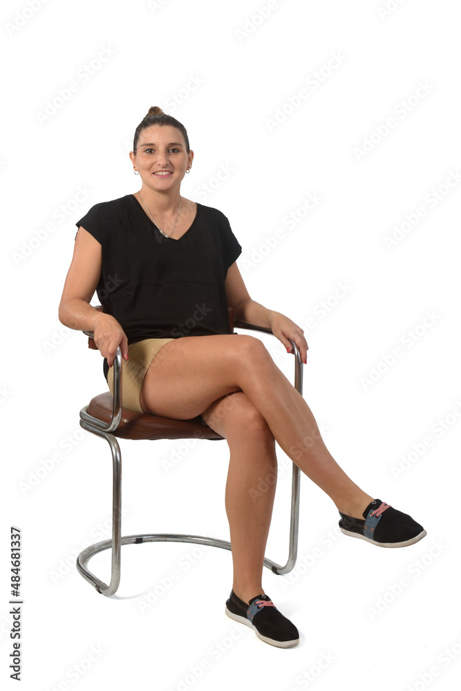 full portrat of a woman sitting on chair legs crossed on white ...