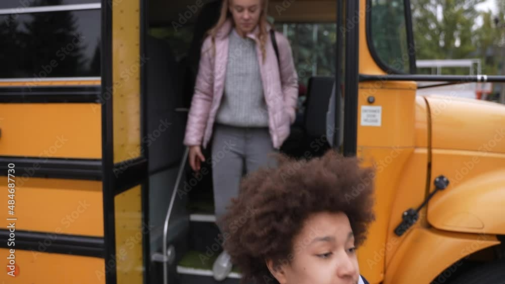 Close-up of multinational high school students leaving doors of school ...