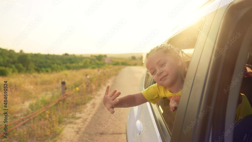 child waves from the car window. happy family a travel kid dream ...