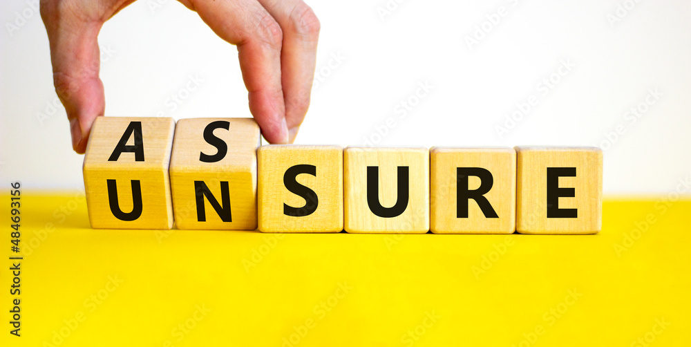Assure or unsure symbol. Businessman turns wooden cubes and changes the ...