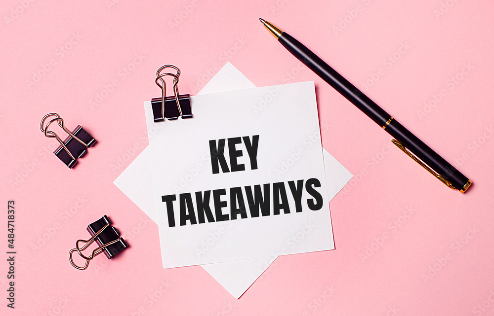 On a light pink background, black paper clips, black pen and white note ...