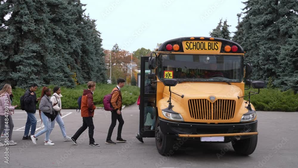 Side view of multinational high school students with backpacks getting ...